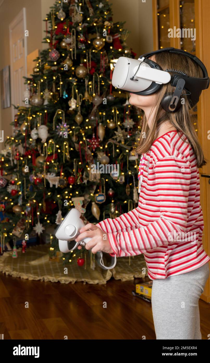 Young girl playing a game at Christmas on a modern virtual reality VR ...