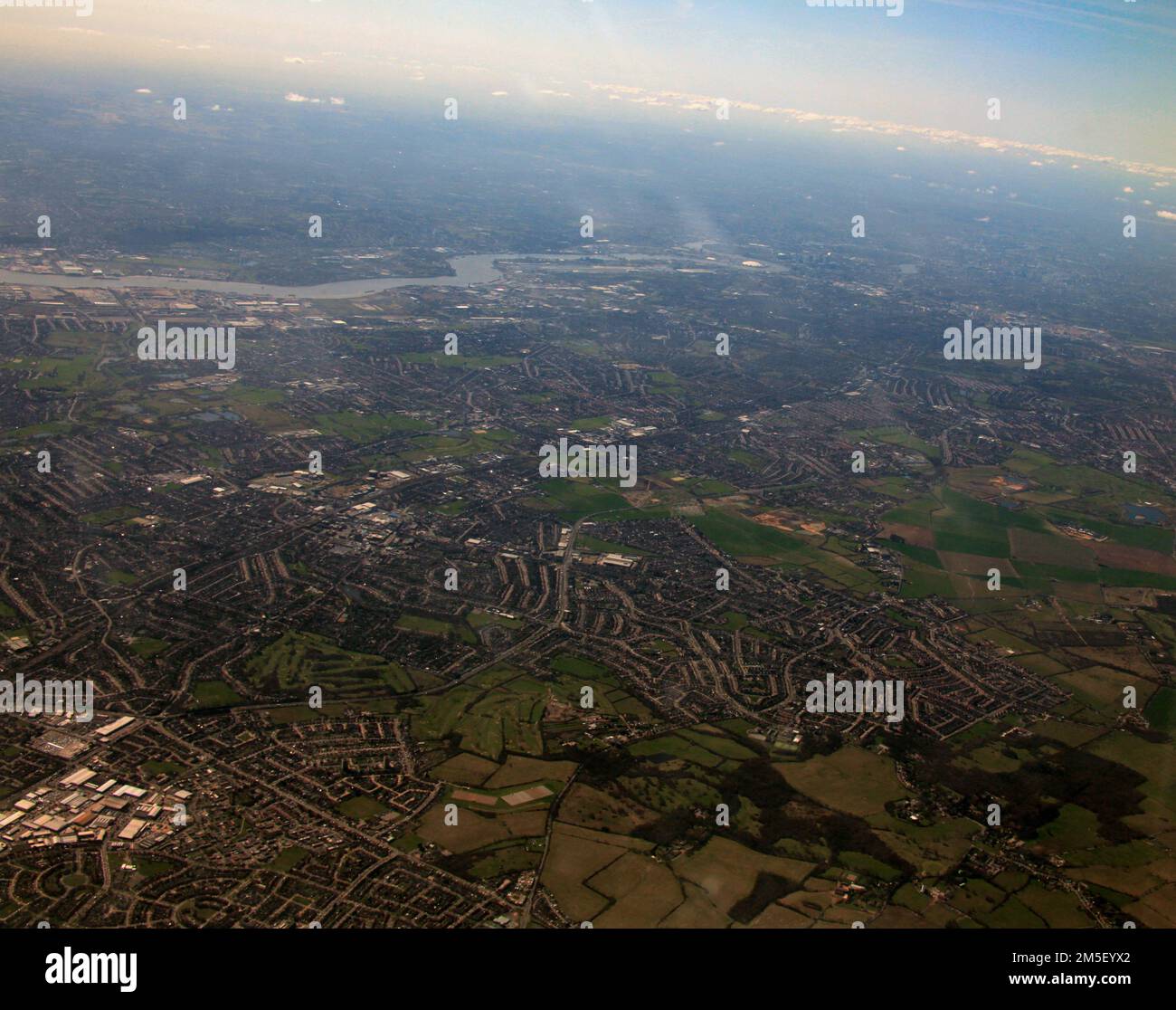 An aerial shot of green fields, buildings and roads during daytime from ...