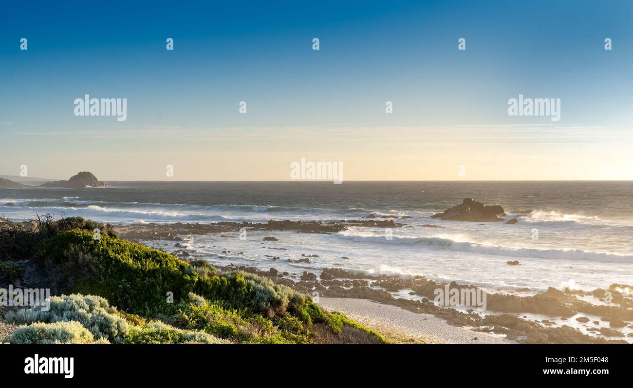 A scenic view of the ocean with sandy coast surrounded by cliffs on a ...