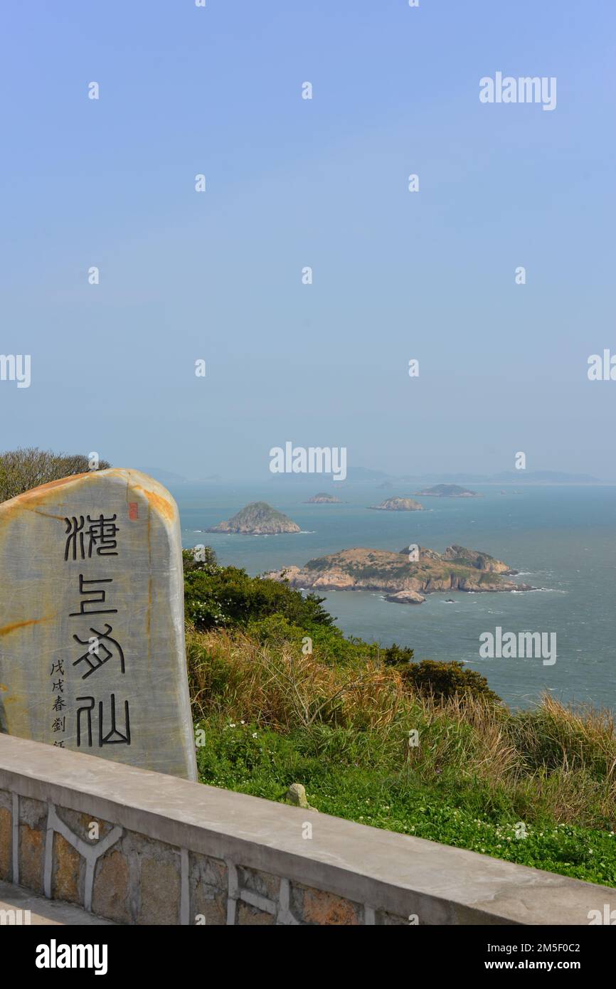 A vertical shot of rocks in the ocean under a blue sky Stock Photo - Alamy