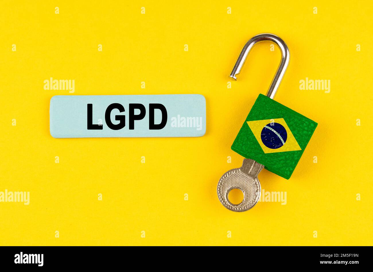 On a yellow surface, an open lock with the image of the flag of Brazil ...