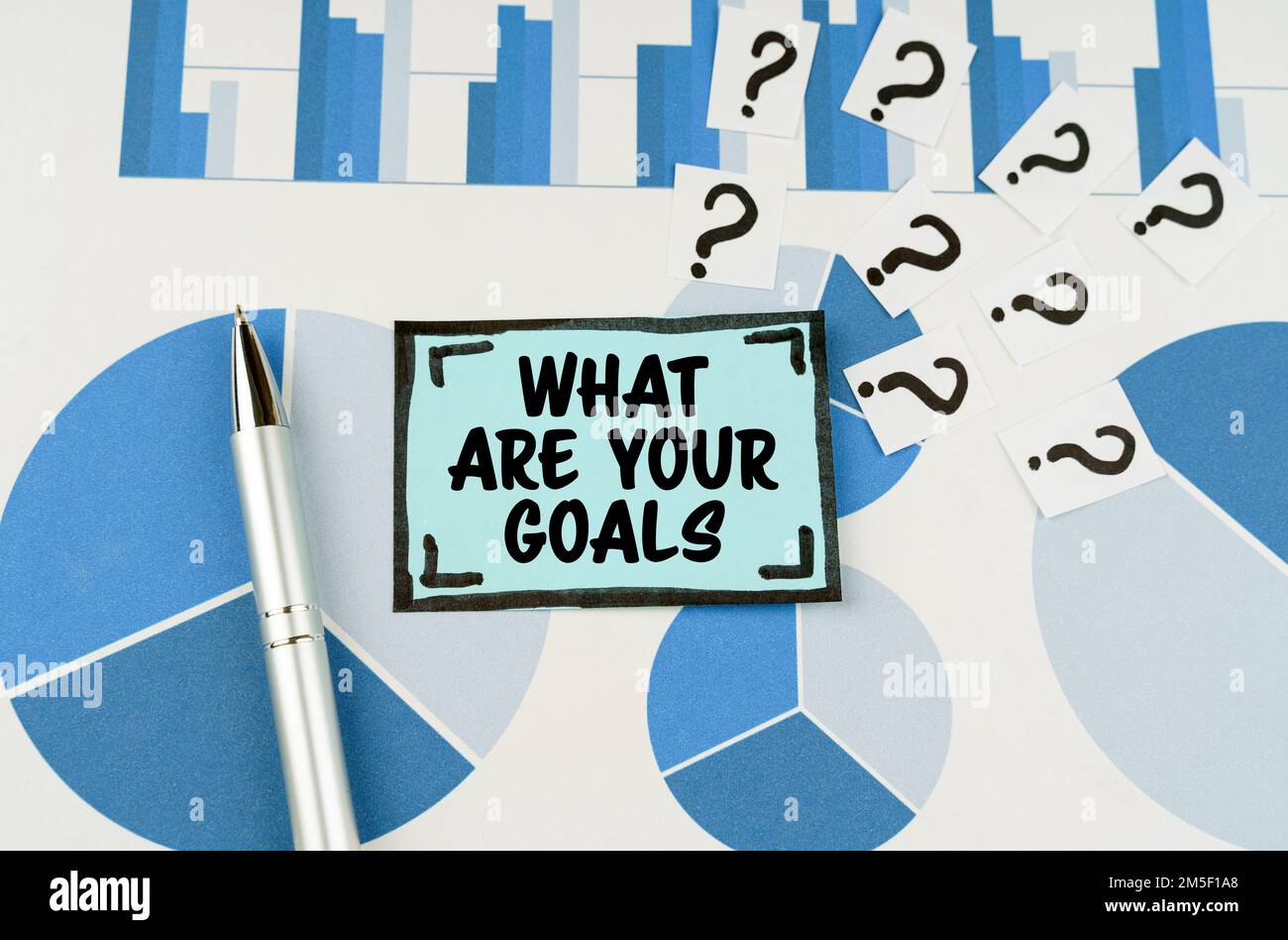 business question concept. On the blue diagrams lies a pen, questions ...