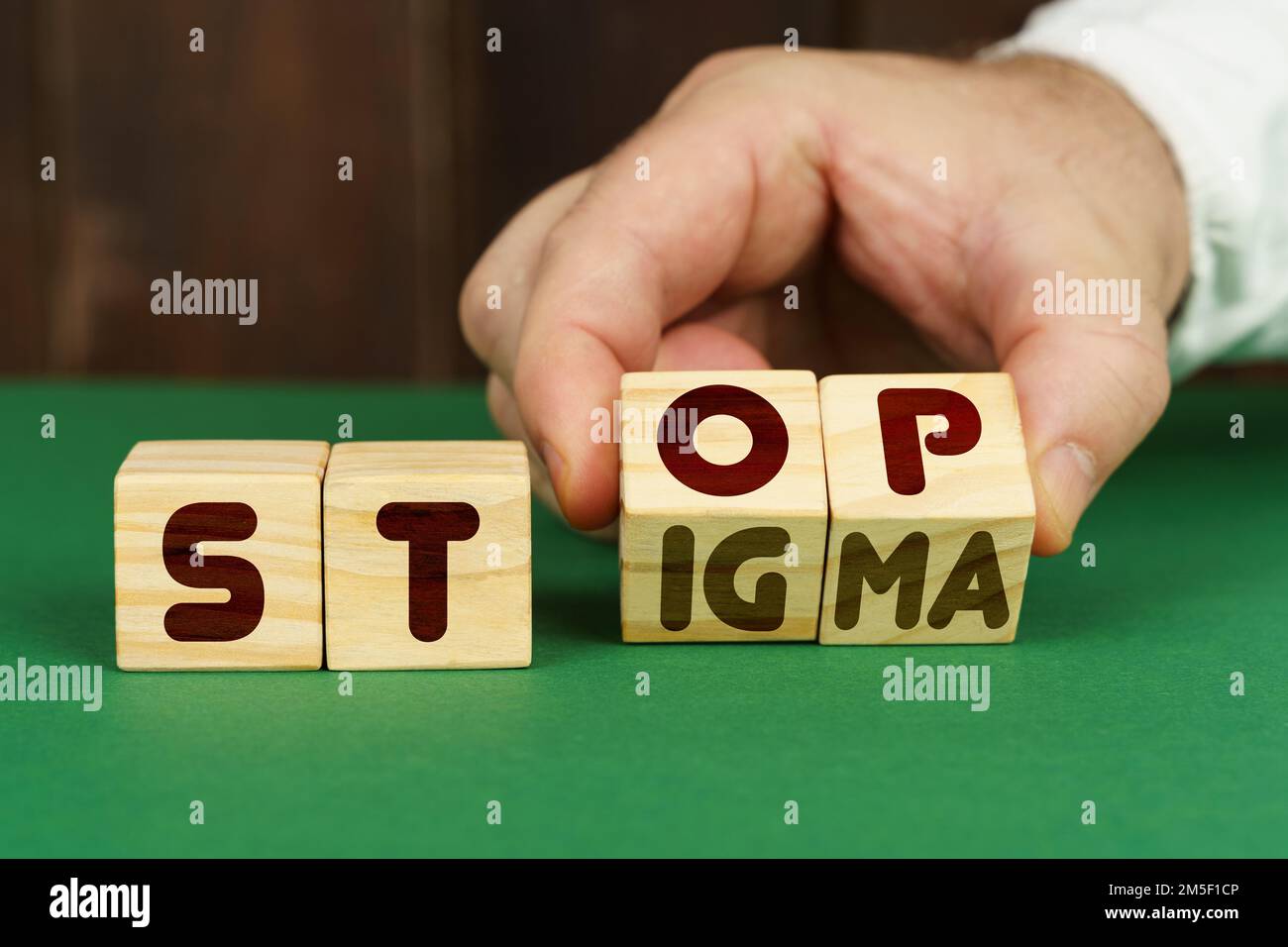 Medicine concept. On a green surface, a man puts cubes with the ...
