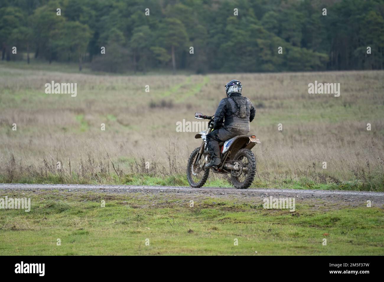 A rear view of a motor cyclist (biker) riding their off-road motorbike ...