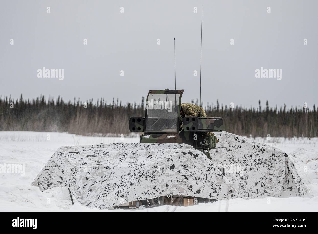 An arctic camouflage tarp covers an Avenger air defense system during ...