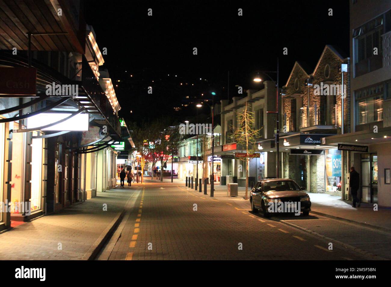 A mesmerizing night view of a street with illuminated shops in ...