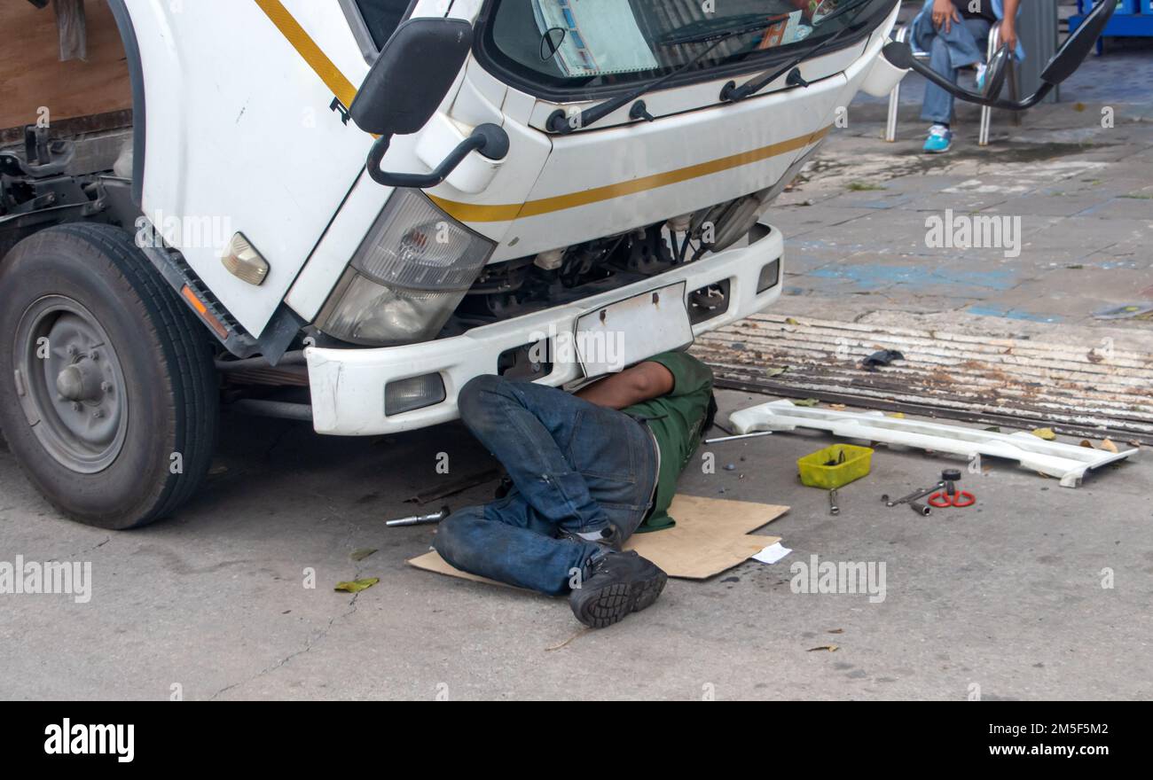 A man is repairing a truck engine on the street Stock Photo - Alamy