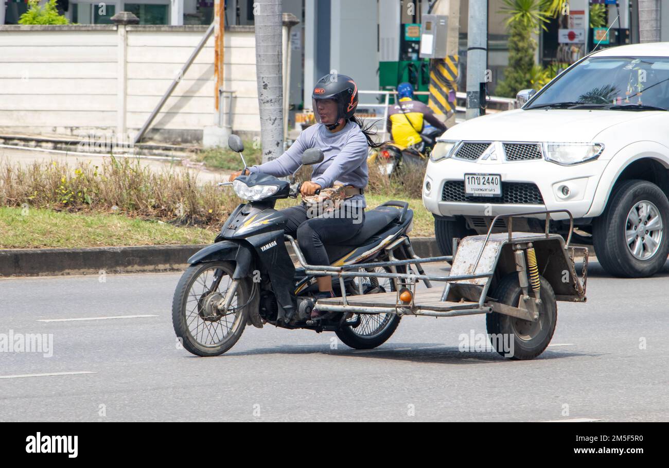 RATCHABURI, THAILAND, NOV 16 2022, A woman drives a motorcycle with an ...