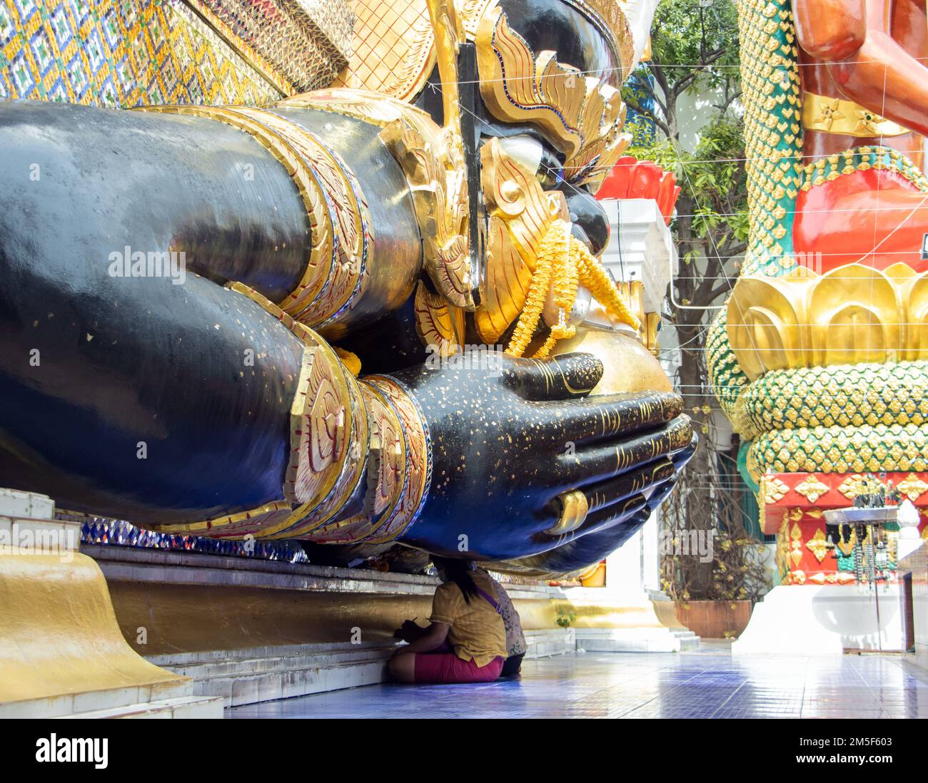 The mythological character Phra Rahu at Buddhist temple with believers ...