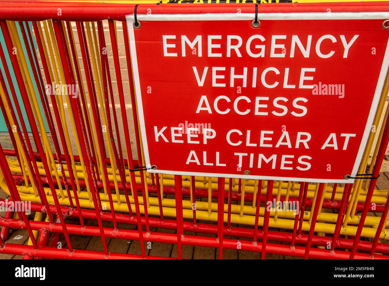 Super colourful red emergency instruction sign against movable metal ...