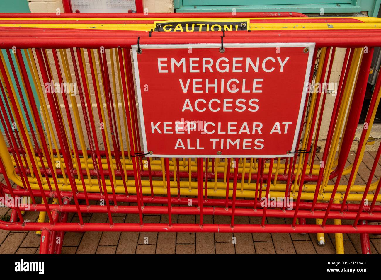 Super colourful red emergency instruction sign against movable metal ...