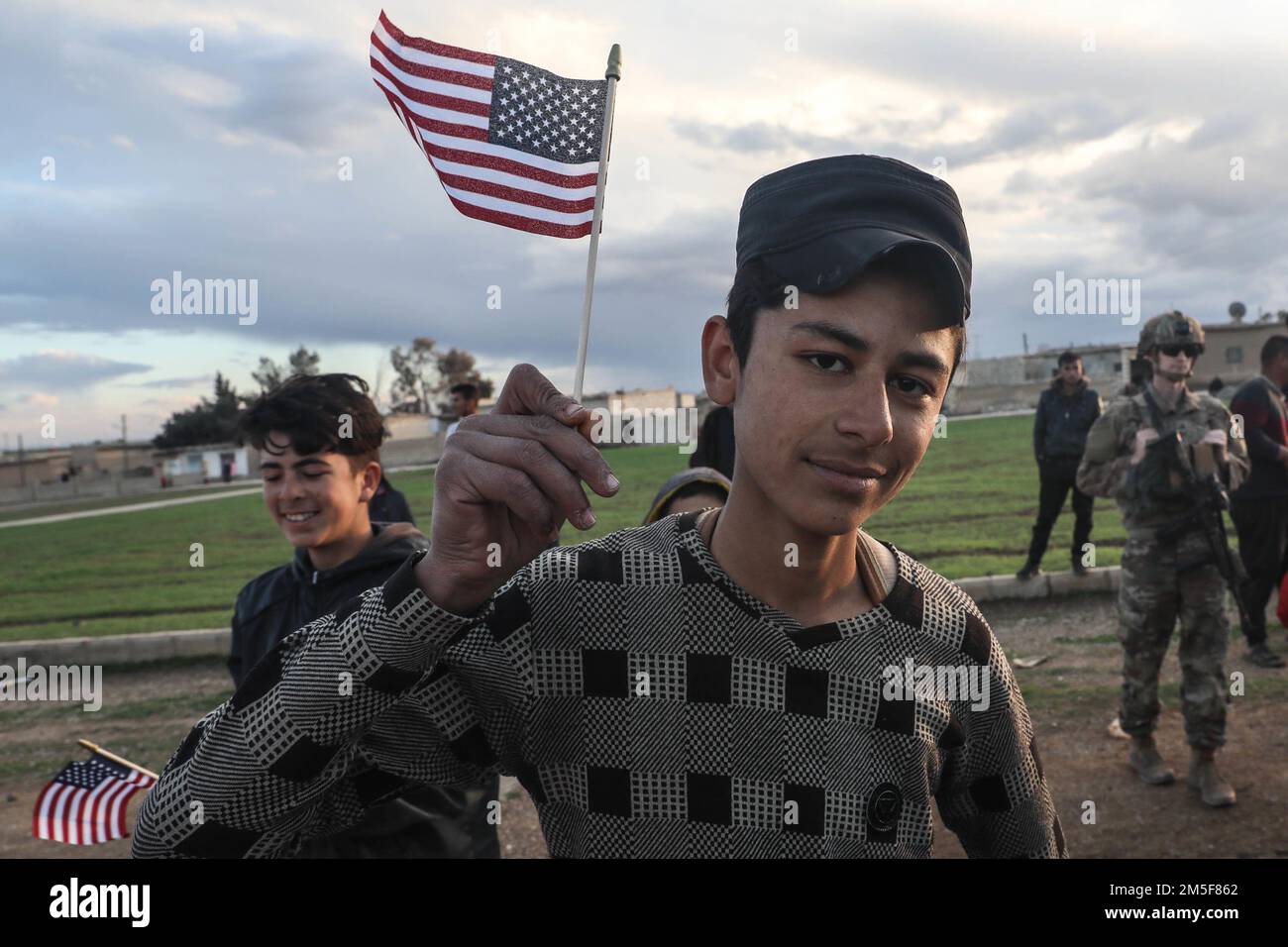 A local in a small village holds the American flag in Northeast Syria ...