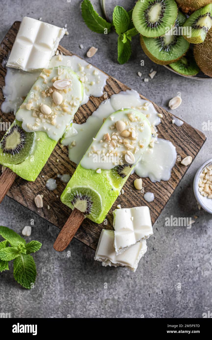 Homemade vegan kiwi ice cream bars or popsicles covered with white ...