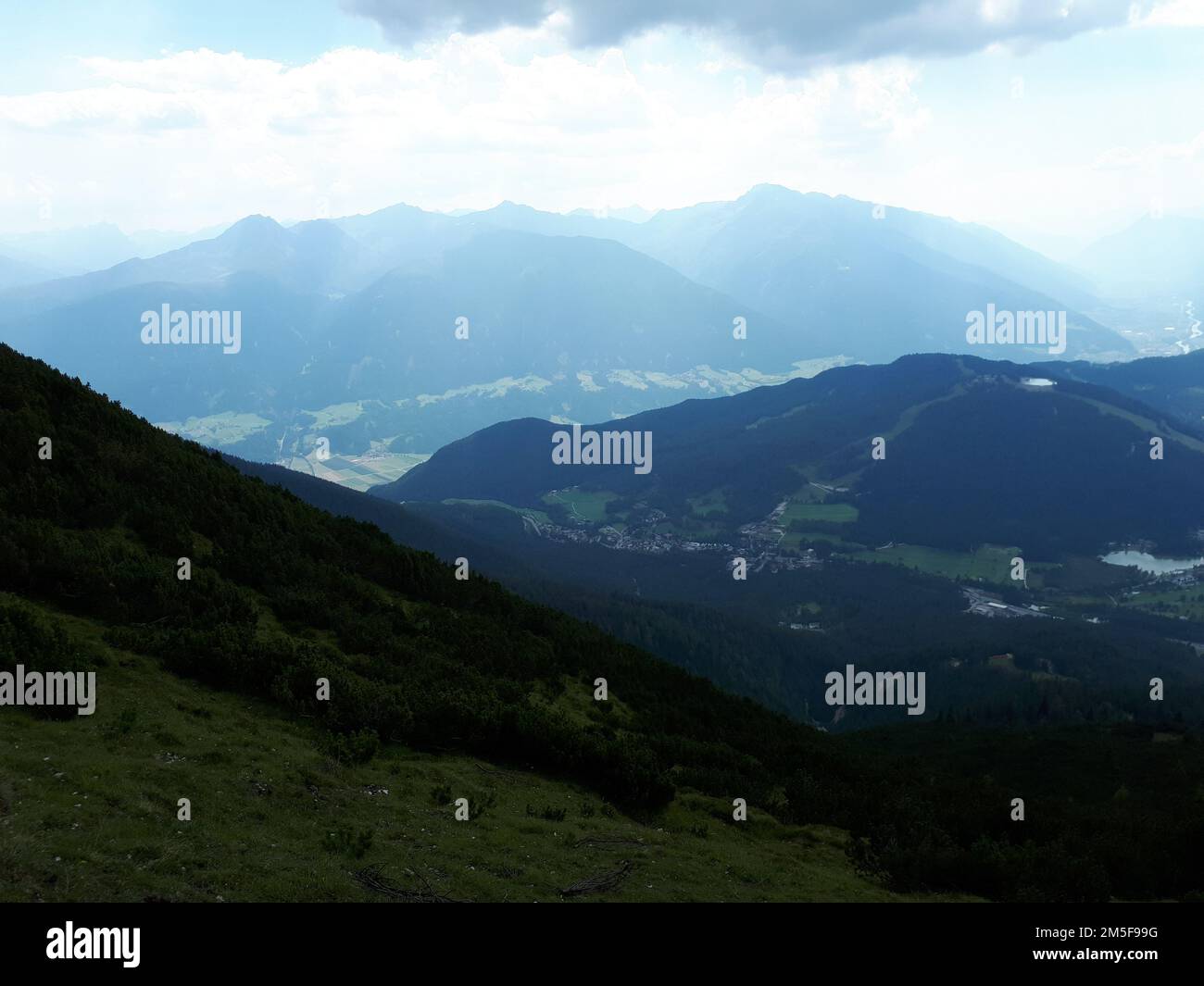 A scenic view of the green mountains and small lakes under cloudy sky ...