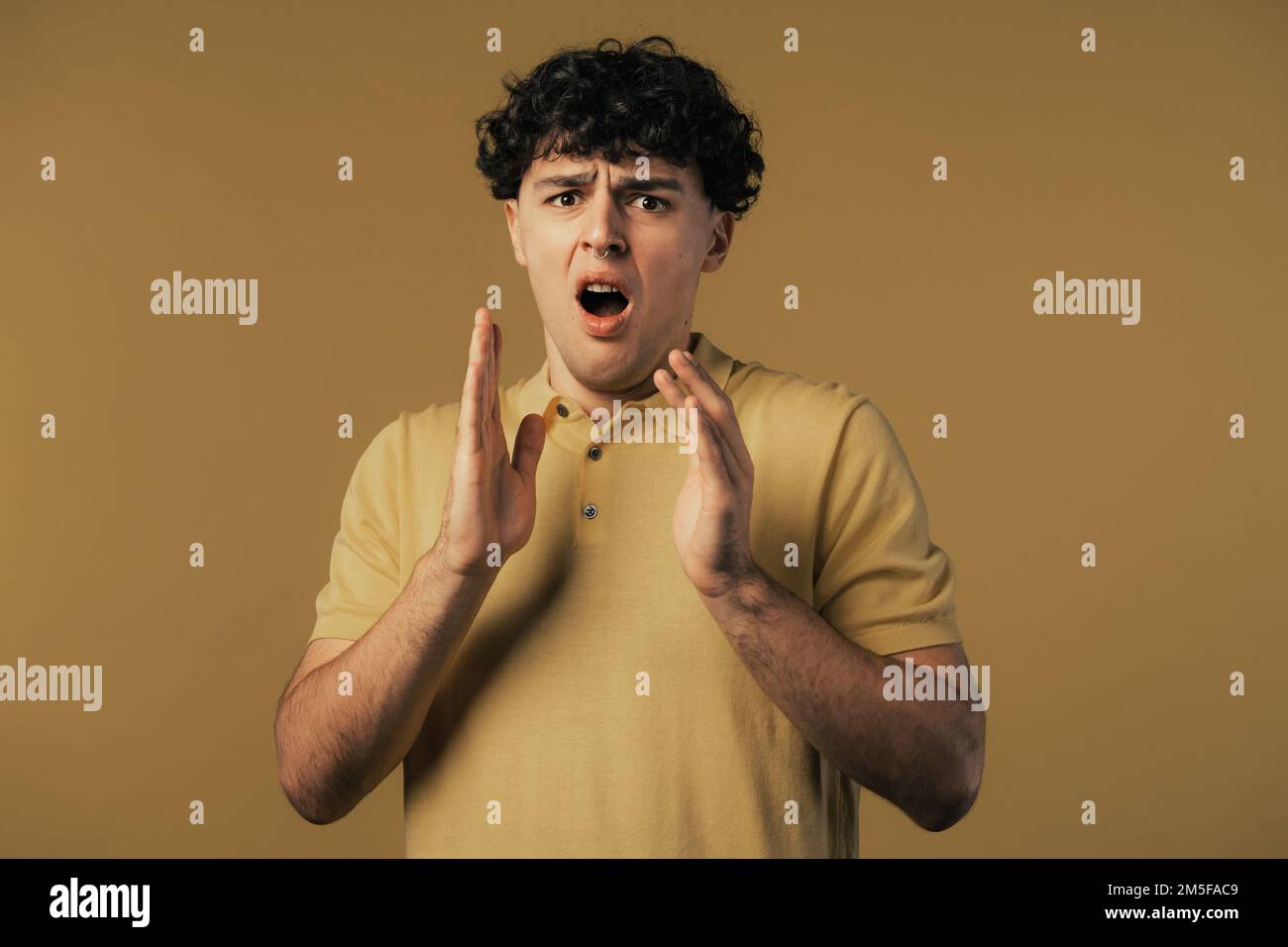 Frightened shocked man afraid of something and looks into camera with ...