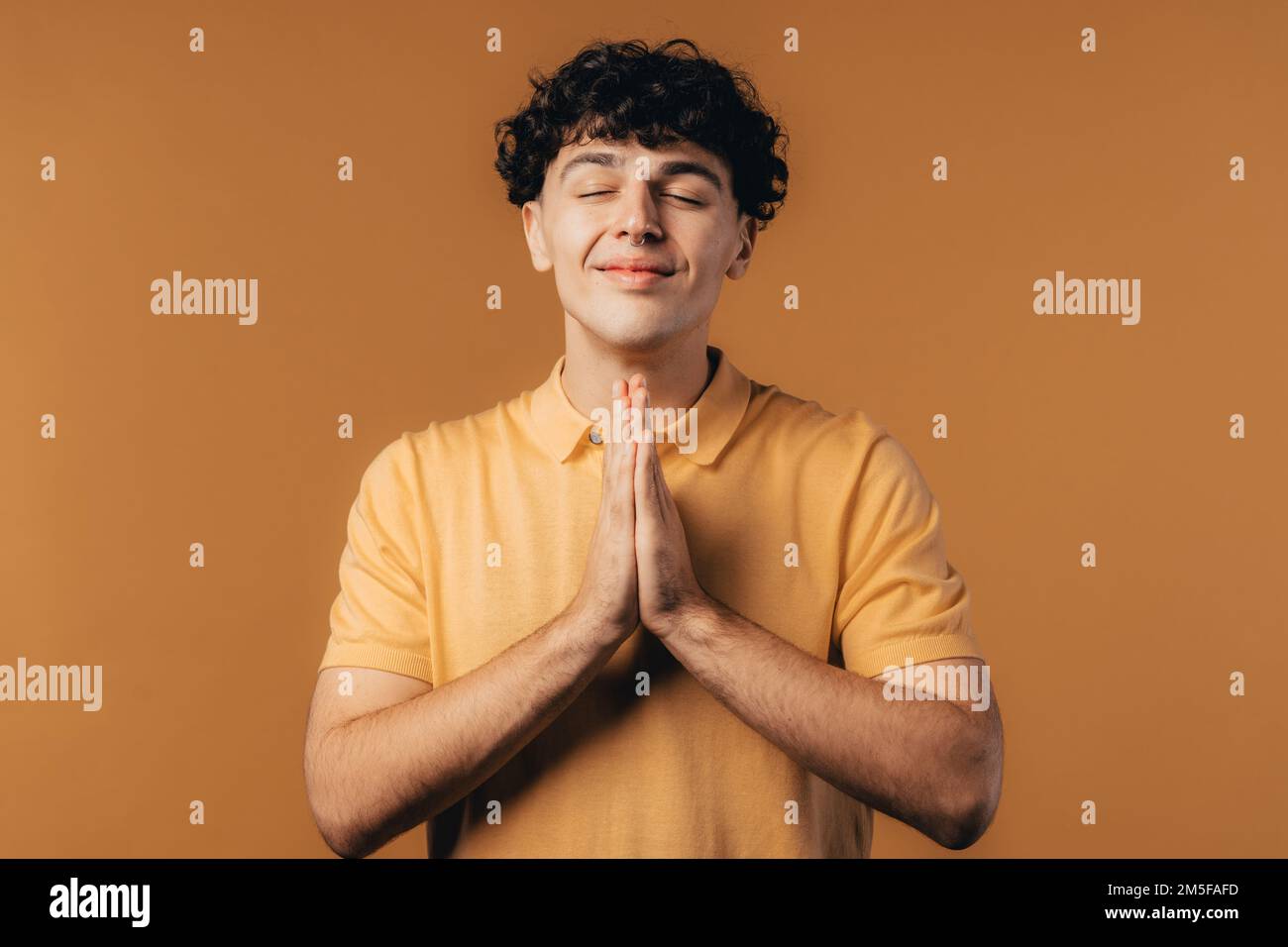 Young man praying, begs to apologize her, he is guilty. Yellow ...