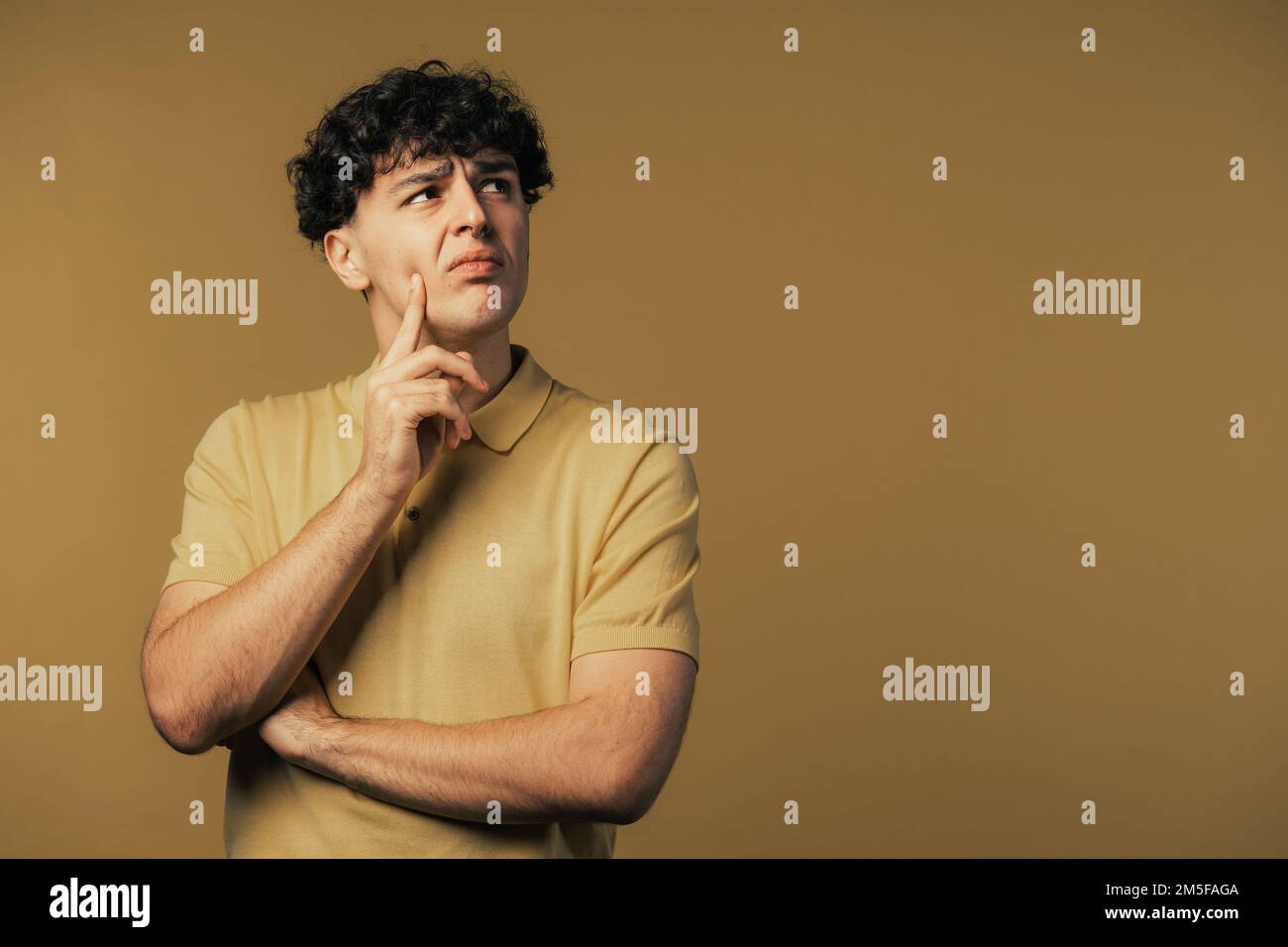 Thinking man looking up and around on yellow background. Worried ...