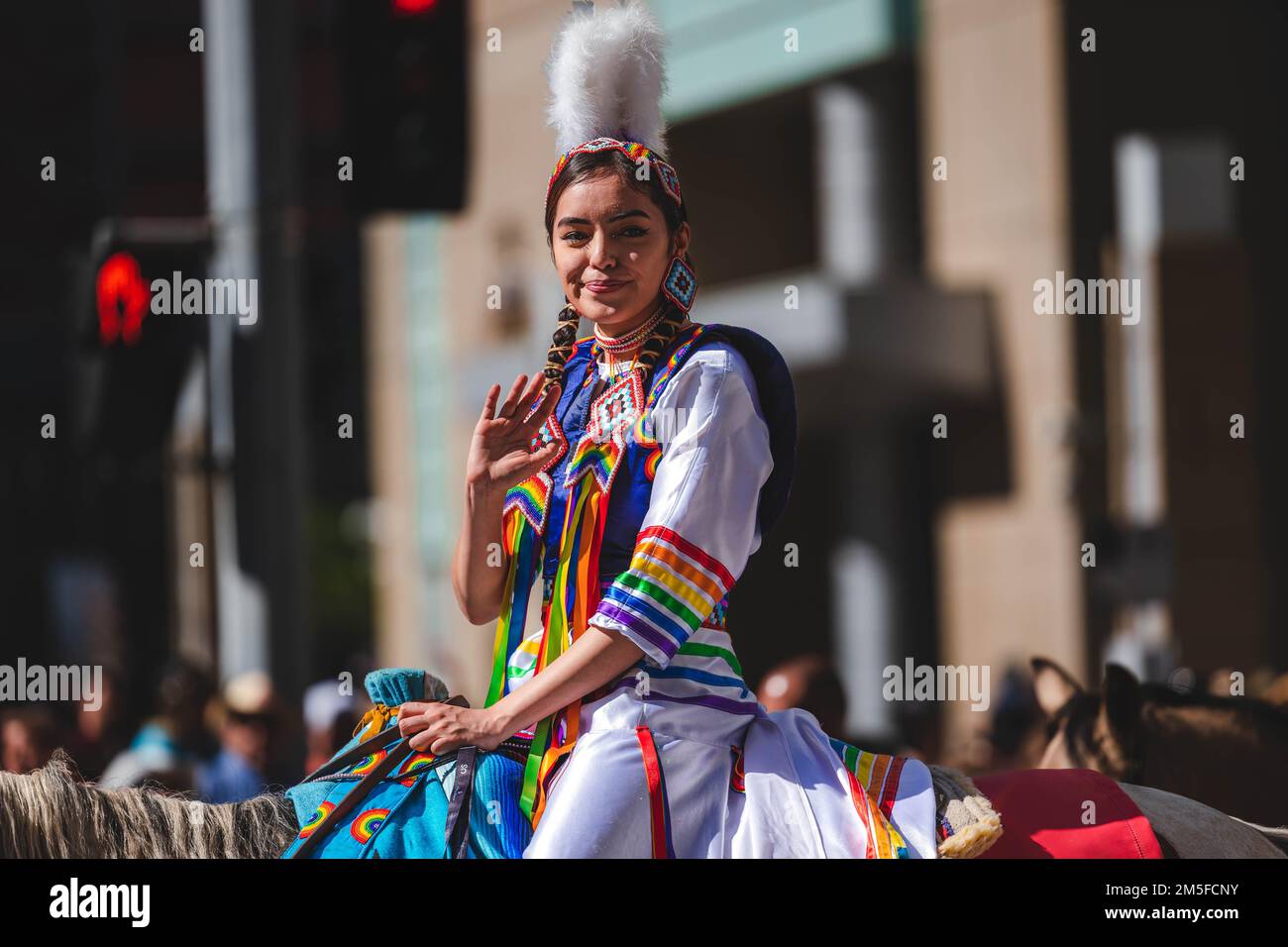 An Indigenous Canadian female in traditional garments riding on a horse ...