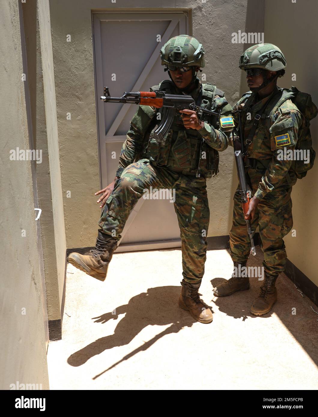 A Rwanda Defence Force Soldier kicks a door in while in training to ...