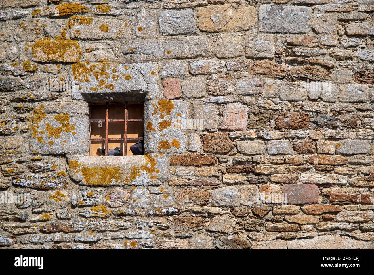 Barred window in a natural stone wall as background Stock Photo - Alamy