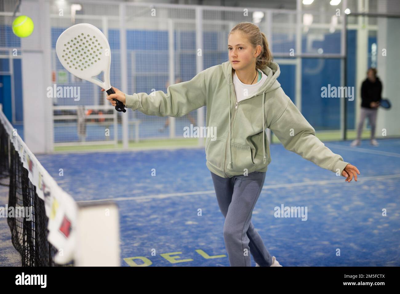 Teenage girl playing padel in court Stock Photo - Alamy
