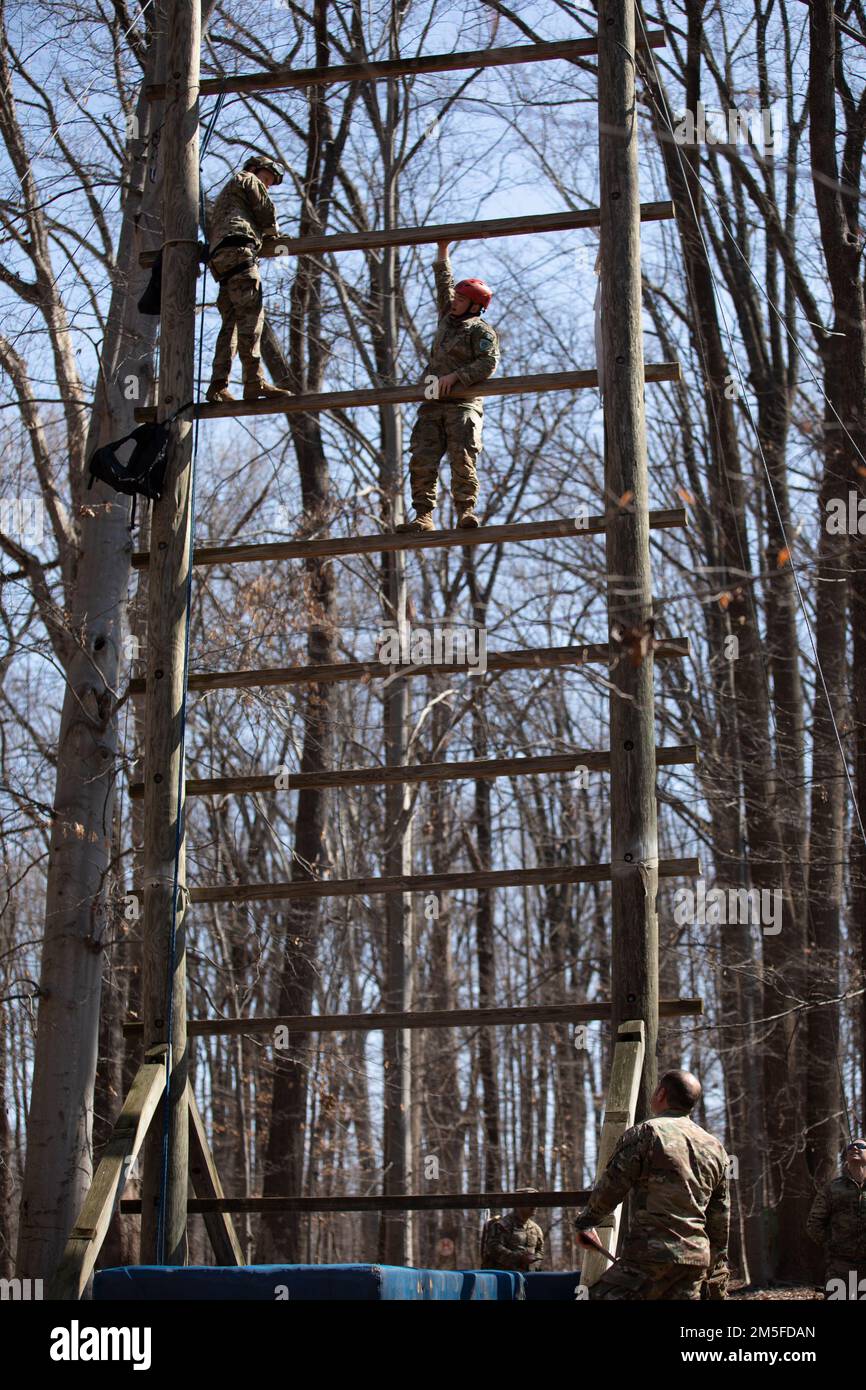 A competitor scales a high obstacle during the obstacle course event of ...