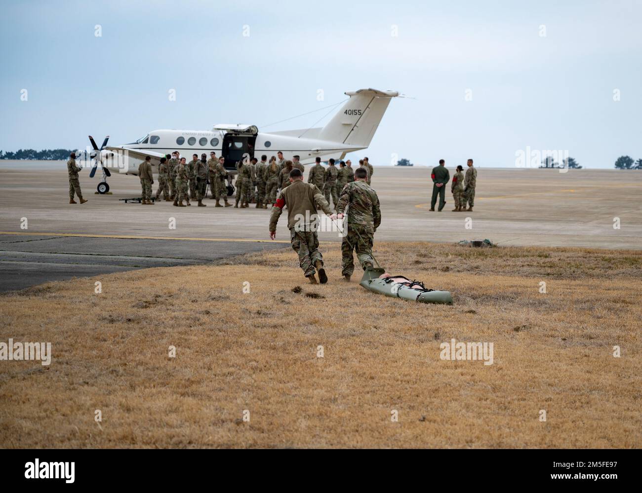 Airmen assigned to the 8th Medical Group drag a casualty mannequin to a ...
