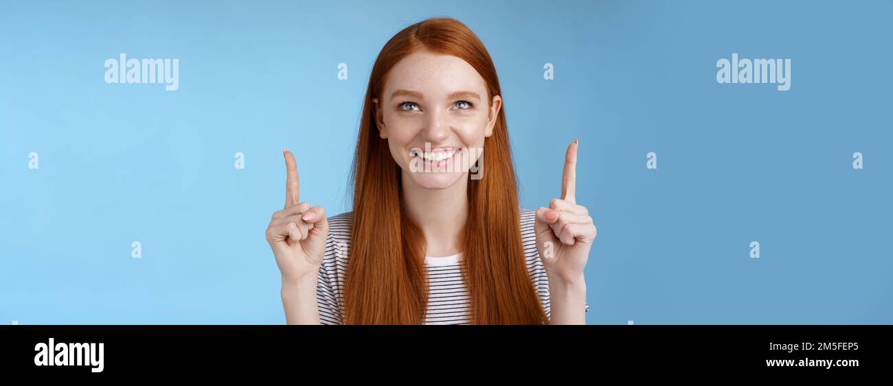 Amused excited happy smiling redhead girl look pointing up grinning ...