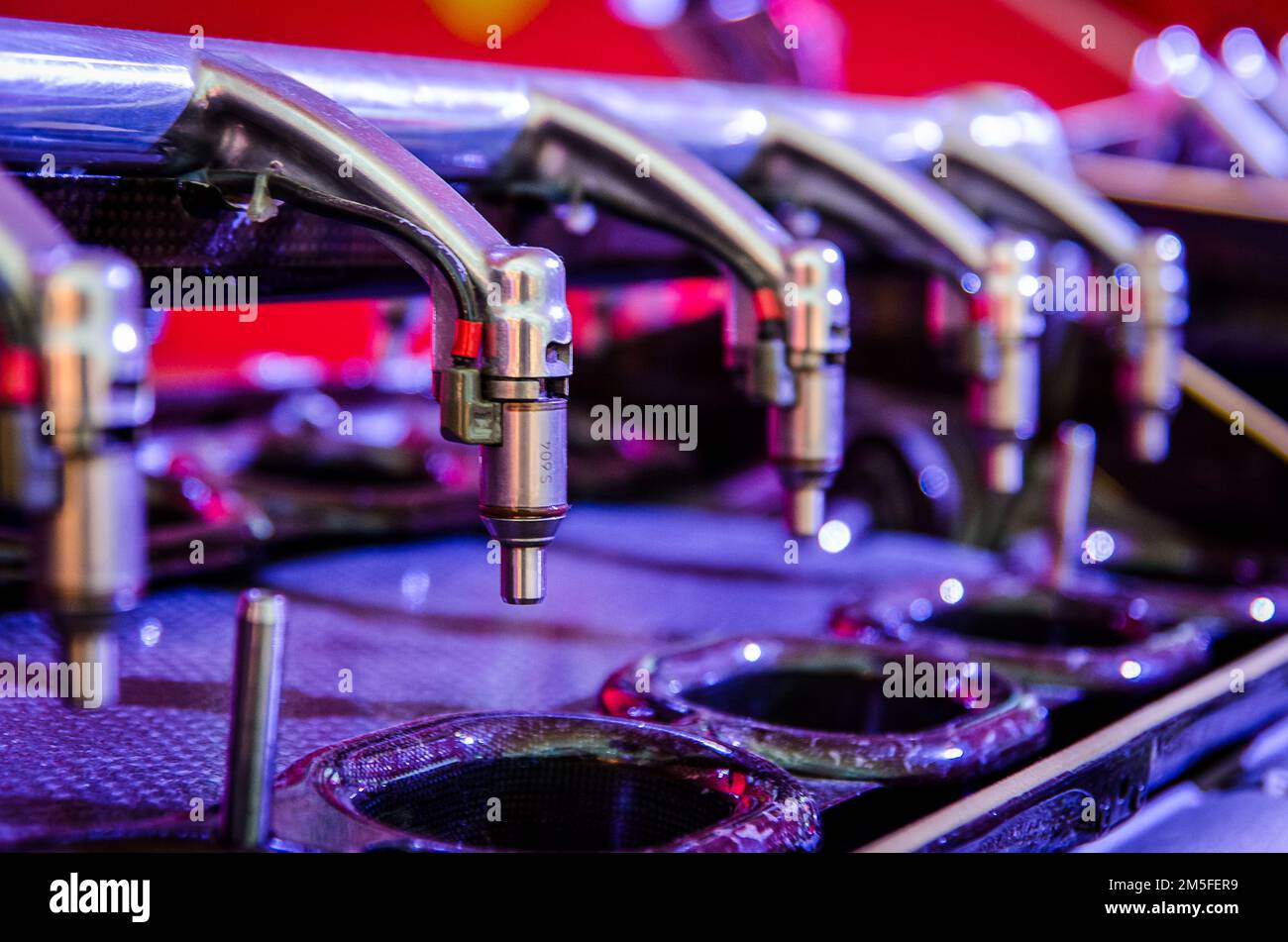 A closeup of details of a formula one motors fuel rail and injectors ...