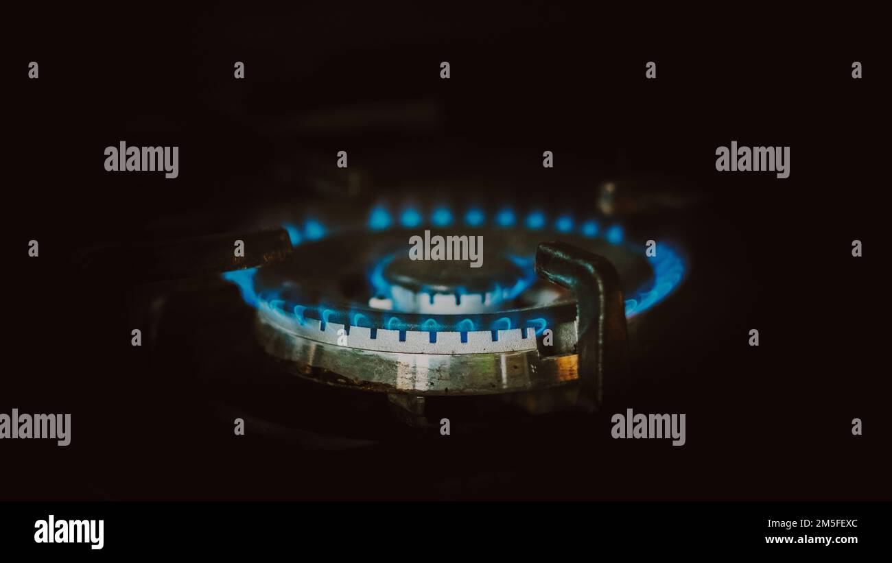 A closeup of a switched gas plate for cooking in the kitchen, dark ...