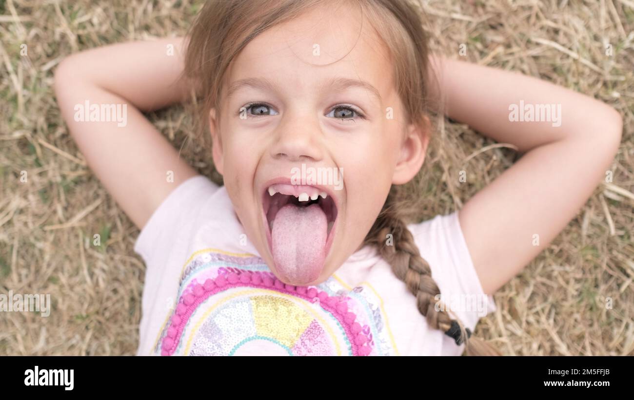 Little Happy Toothless Smiling Child Girl Laying on Yellow Lawn Dry ...