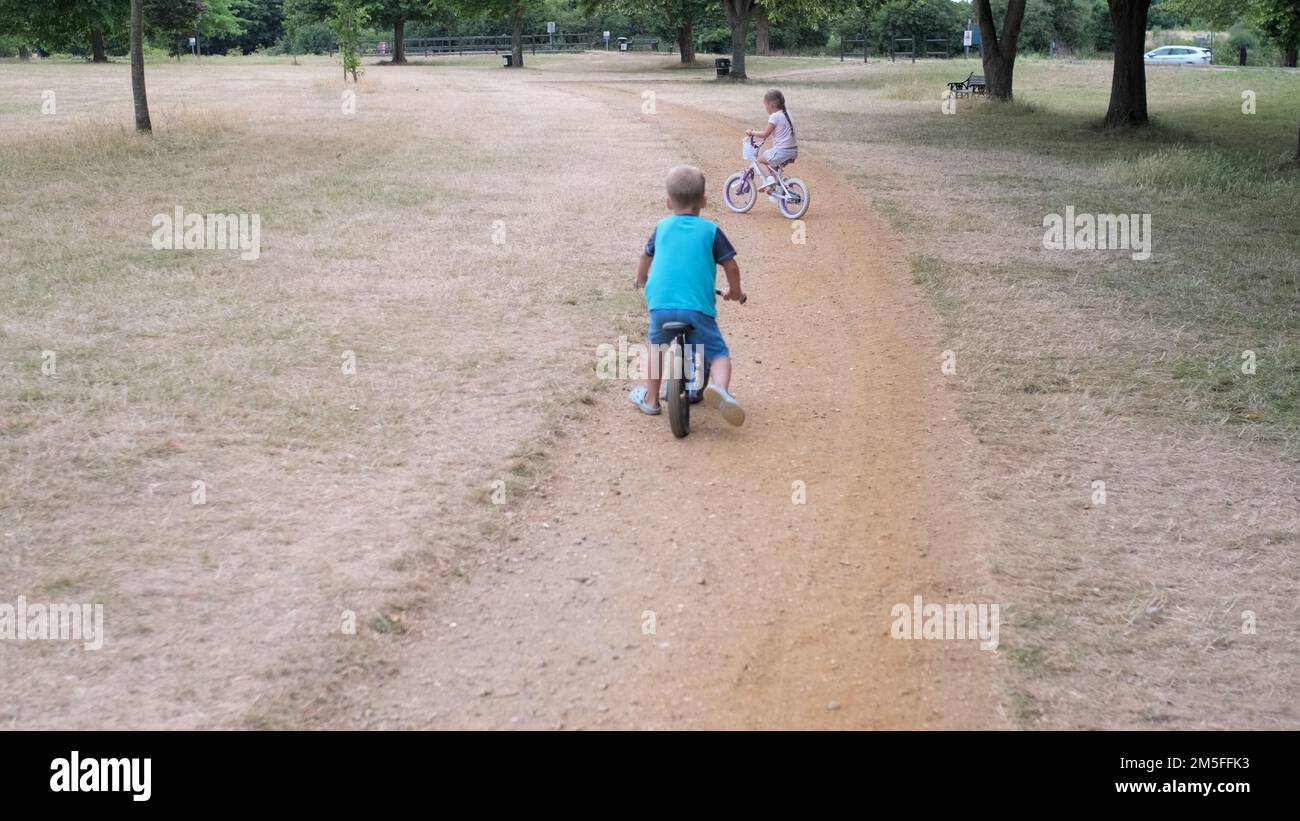 Sport activity for children. Small kids playing bicycle and scooter ...