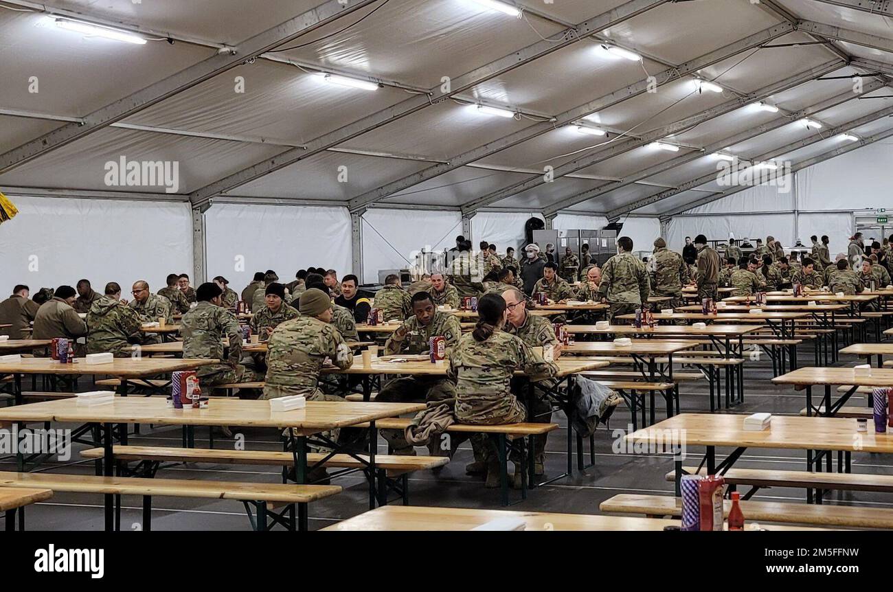 Soldiers eat dinner at a dining facility tent in Mielec, Poland. Using ...