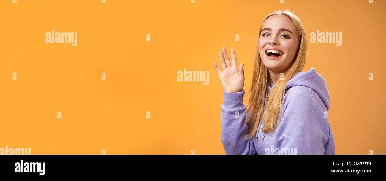 Waist-up friendly lucky cute blond girl waving palm happily smiling ...