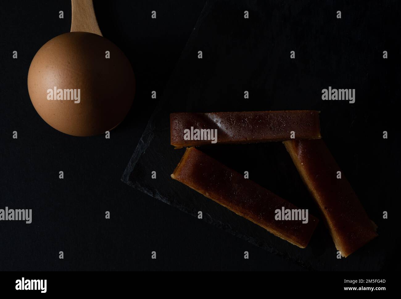 A horizontal flat lay photo of an egg next to a toasted yolk nougat ...