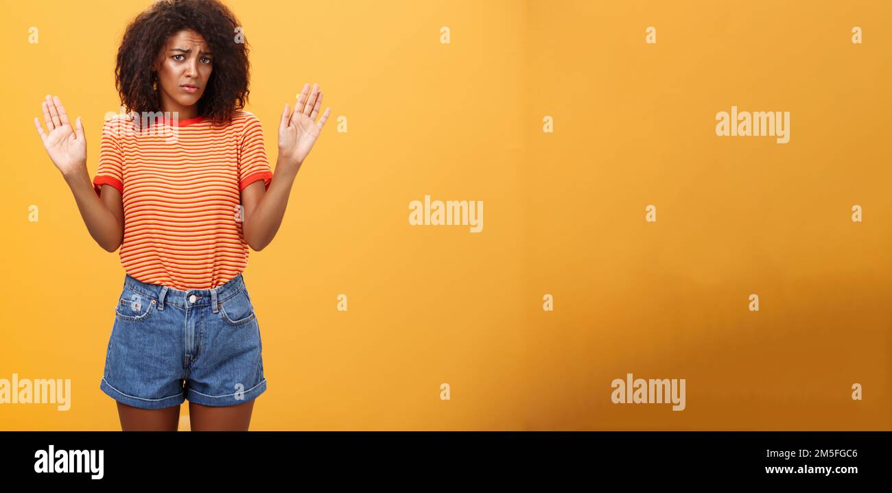 Silly insecure and sad dark-skinned female model in trendy striped t ...