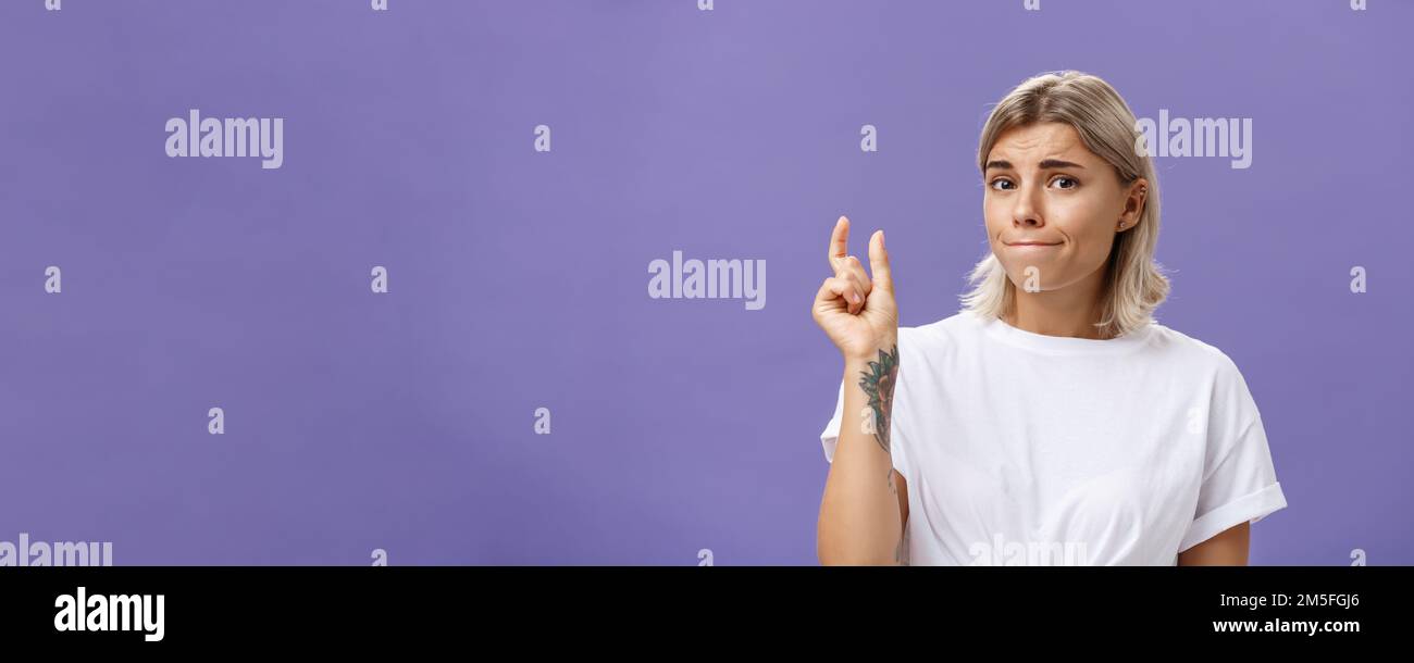 Girl having tiny problem. Concerned attractive blonde girl with tattoo ...