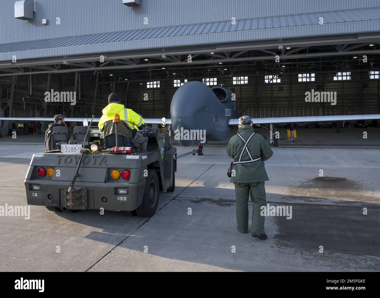 An RQ-4B Global Hawk is moved into a hangar on the flight line at ...