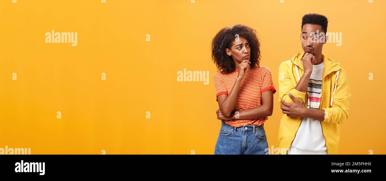 Silly confused girl standing gloomy and worried pursing lips and ...