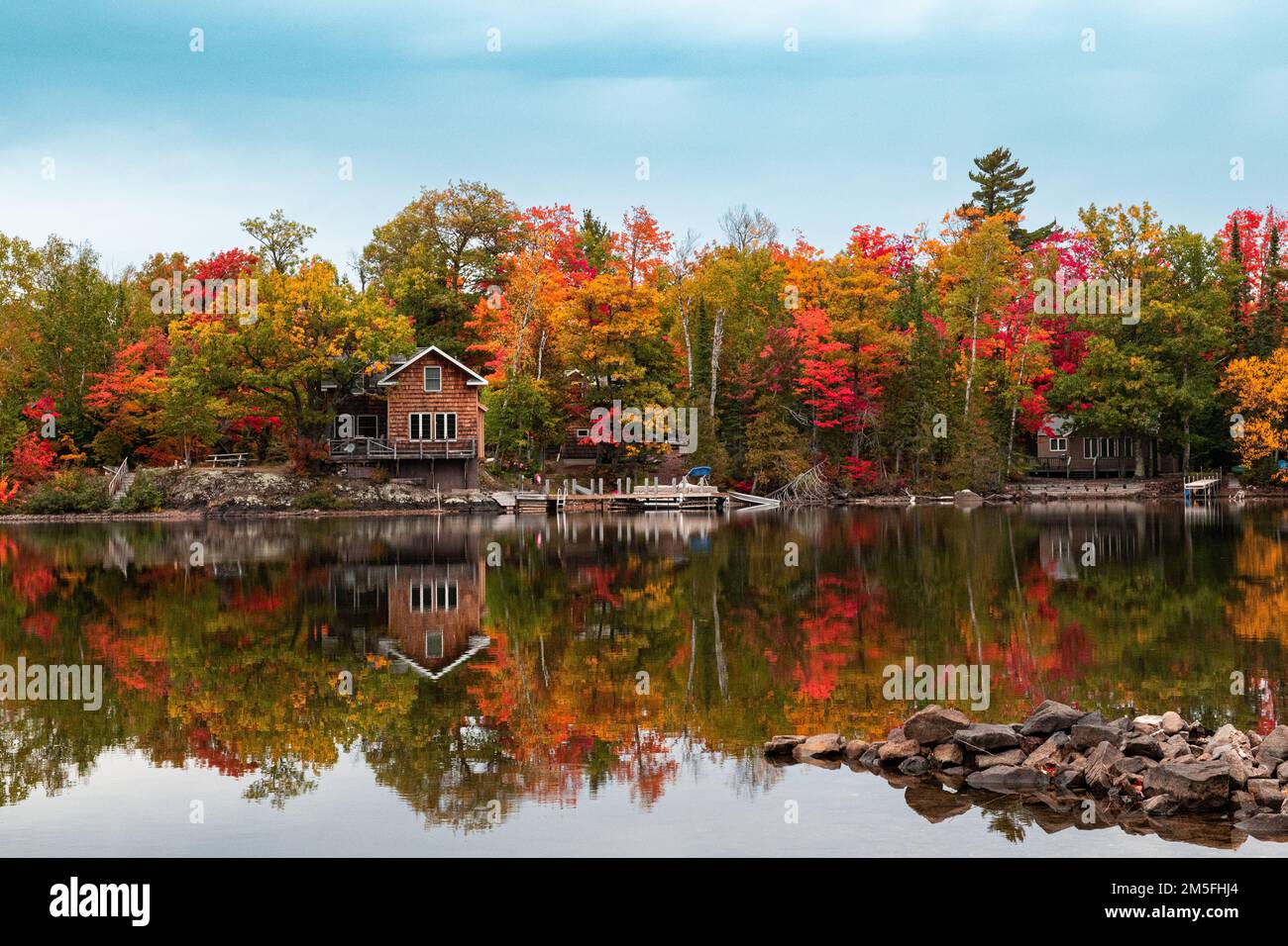 The reflection of a leafy forest in fall colors, autumn foliage and a ...