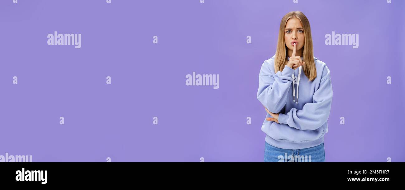 Girl concerned someone know secret making shush gesture with index ...