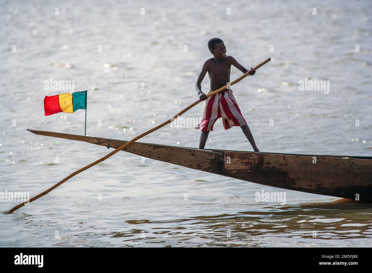 A pirogue with national flag of mali and child in Mopti, Mali, West ...