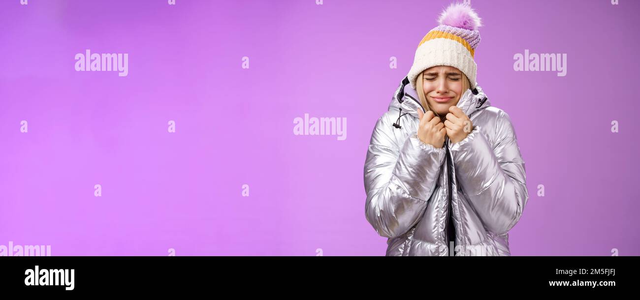 Unhappy sobbing whining cute blond girl pull jacket tight body close ...
