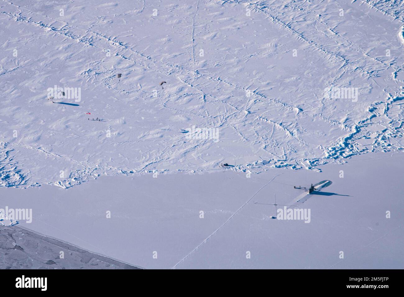 Naval Special Warfare members land on ice after performing a high ...