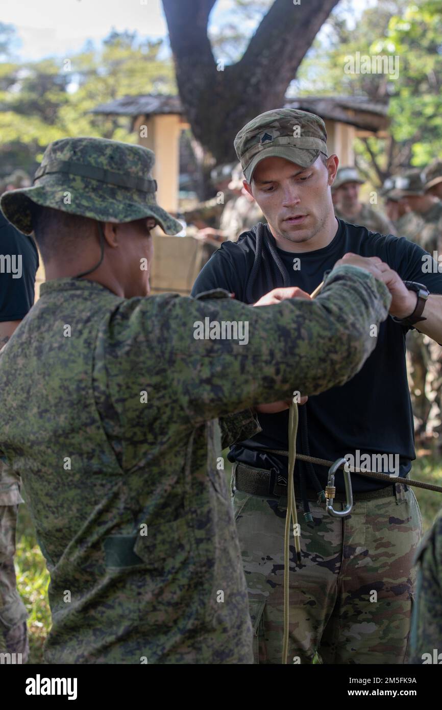 A Jungle Operations Training Course Instructor assists a Philippine Army Soldier on the knot ...