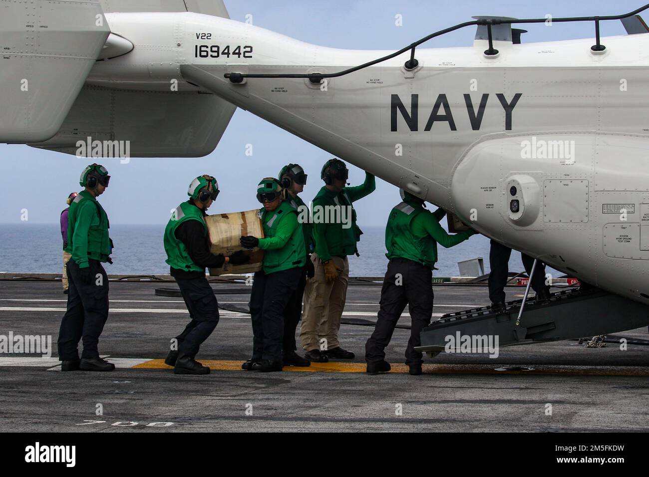 PHILIPPINE SEA (March 14, 2022) Sailors unload cargo from a CMV-22B ...