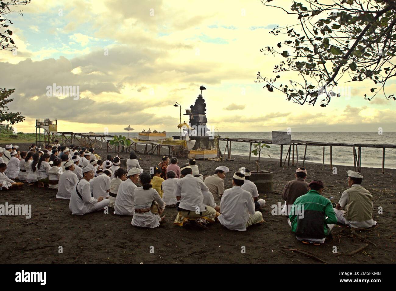A Balinese clan is sitting together as they are getting ready for a ...