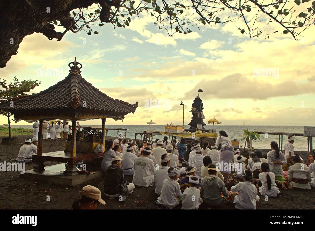 A Balinese clan is sitting together as they are getting ready for a ...