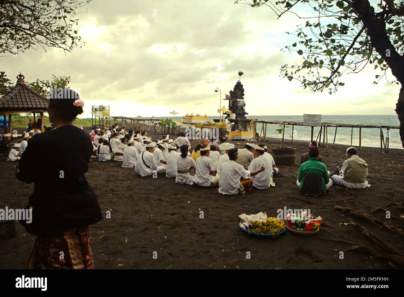 A Balinese clan is sitting together as they are getting ready for a ...