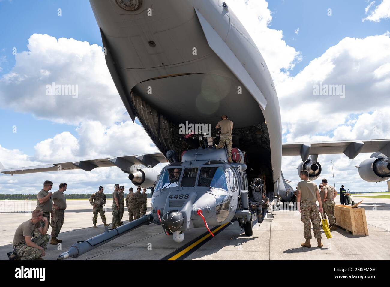 U.S. Air Force Airmen assigned to the 23rd Wing guide an HH-60W Jolly ...